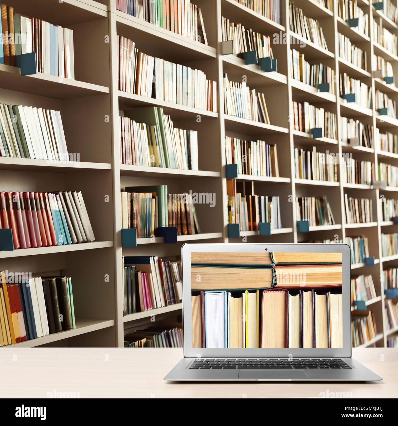 Digital library concept. Modern laptop on table and shelves with books ...