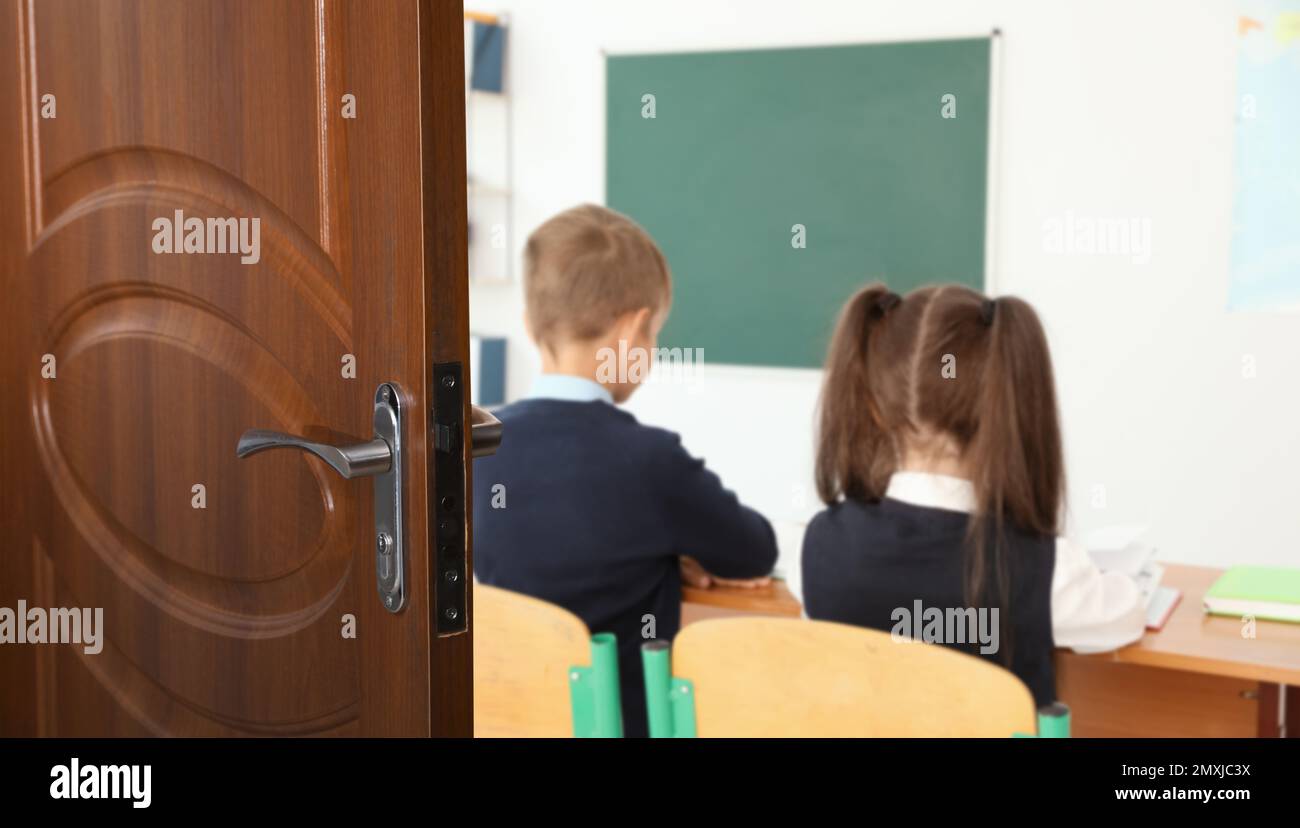 Wooden door open into modern classroom with students, banner design ...