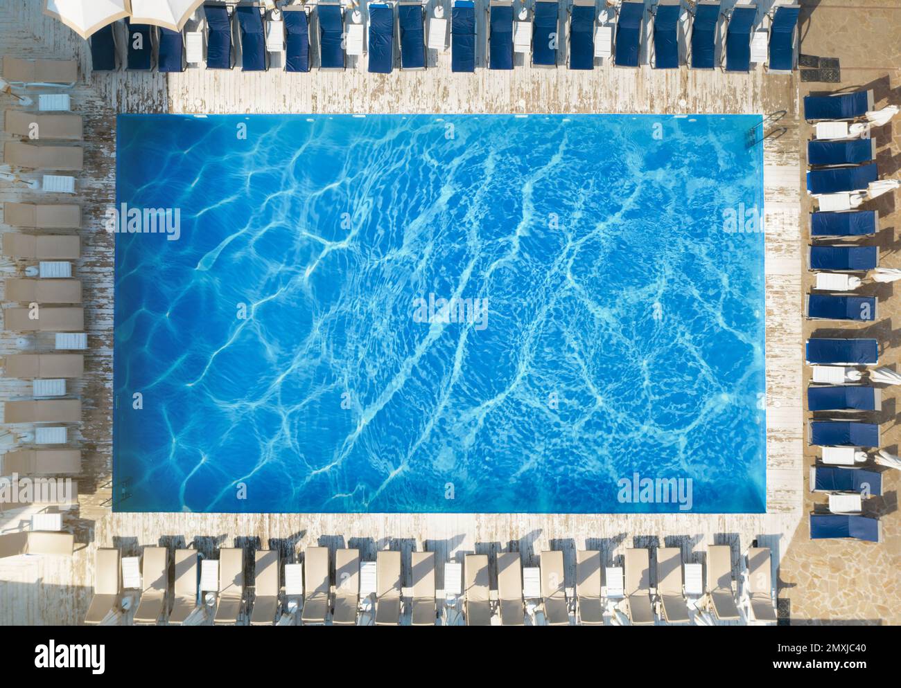 Sun lounge chairs near swimming pool, top view Stock Photo - Alamy