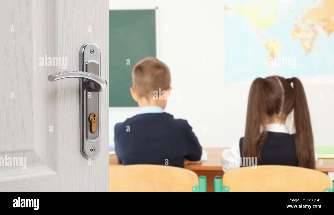 Wooden door open into modern classroom with students Stock Photo - Alamy