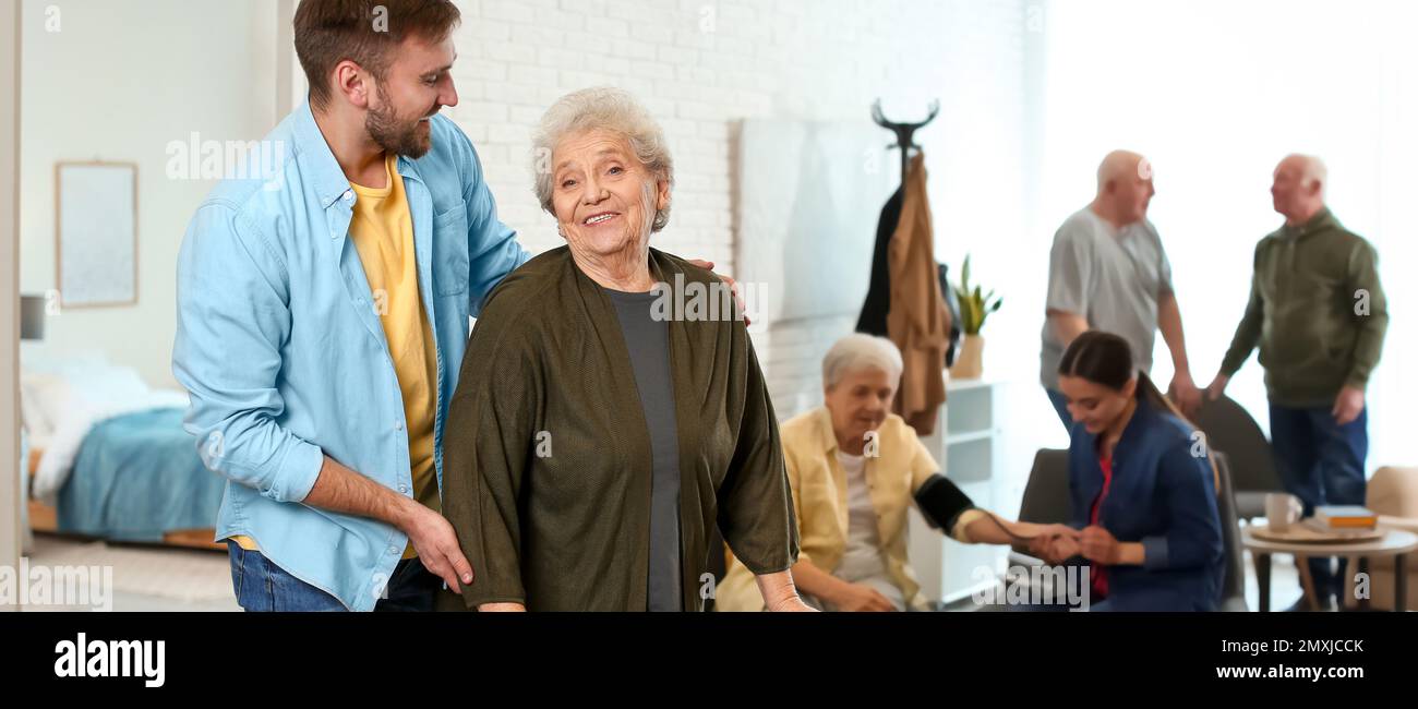 Young man taking care of elderly woman in geriatric hospice. Banner ...