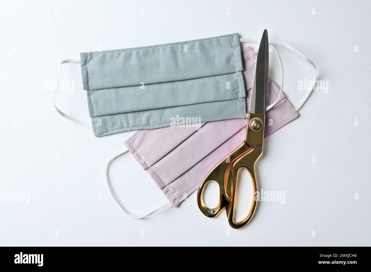 Homemade protective masks and scissors on white background, flat lay ...