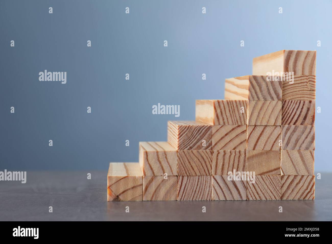 Steps made with wooden blocks on grey table, space for text. Career ...