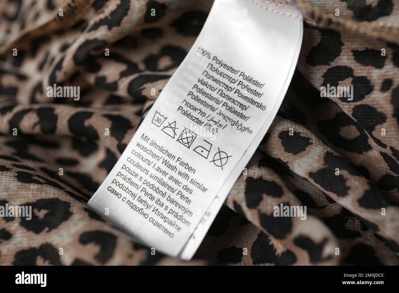 Clothing label with care symbols and material content on shirt, closeup ...
