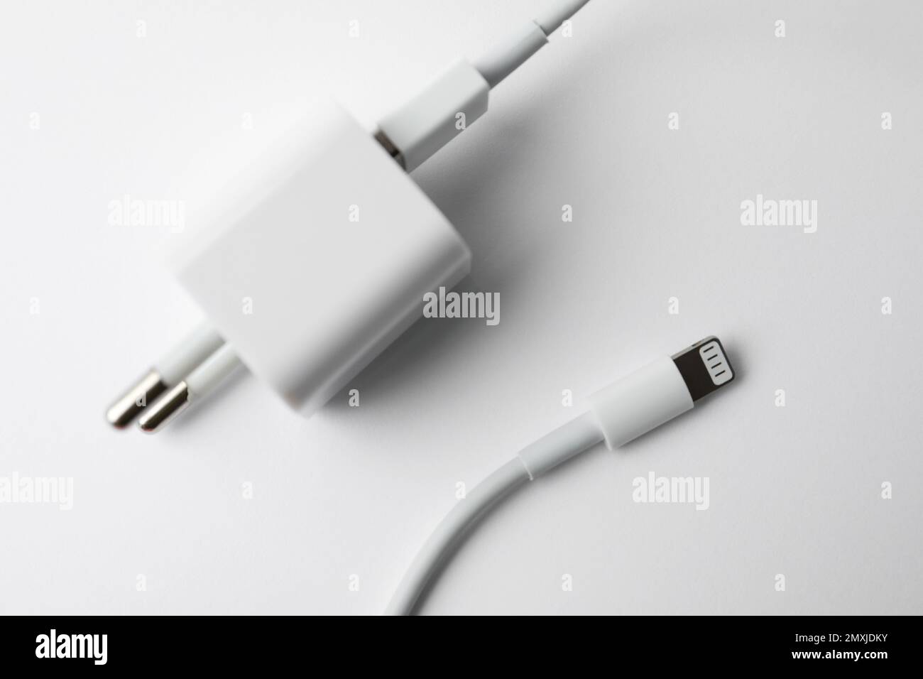 Charging cable and adapter on white background, top view Stock Photo ...