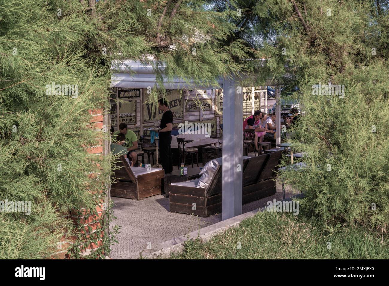 outdoor terrace, surrounded by bushes and green trees, for a bar ...