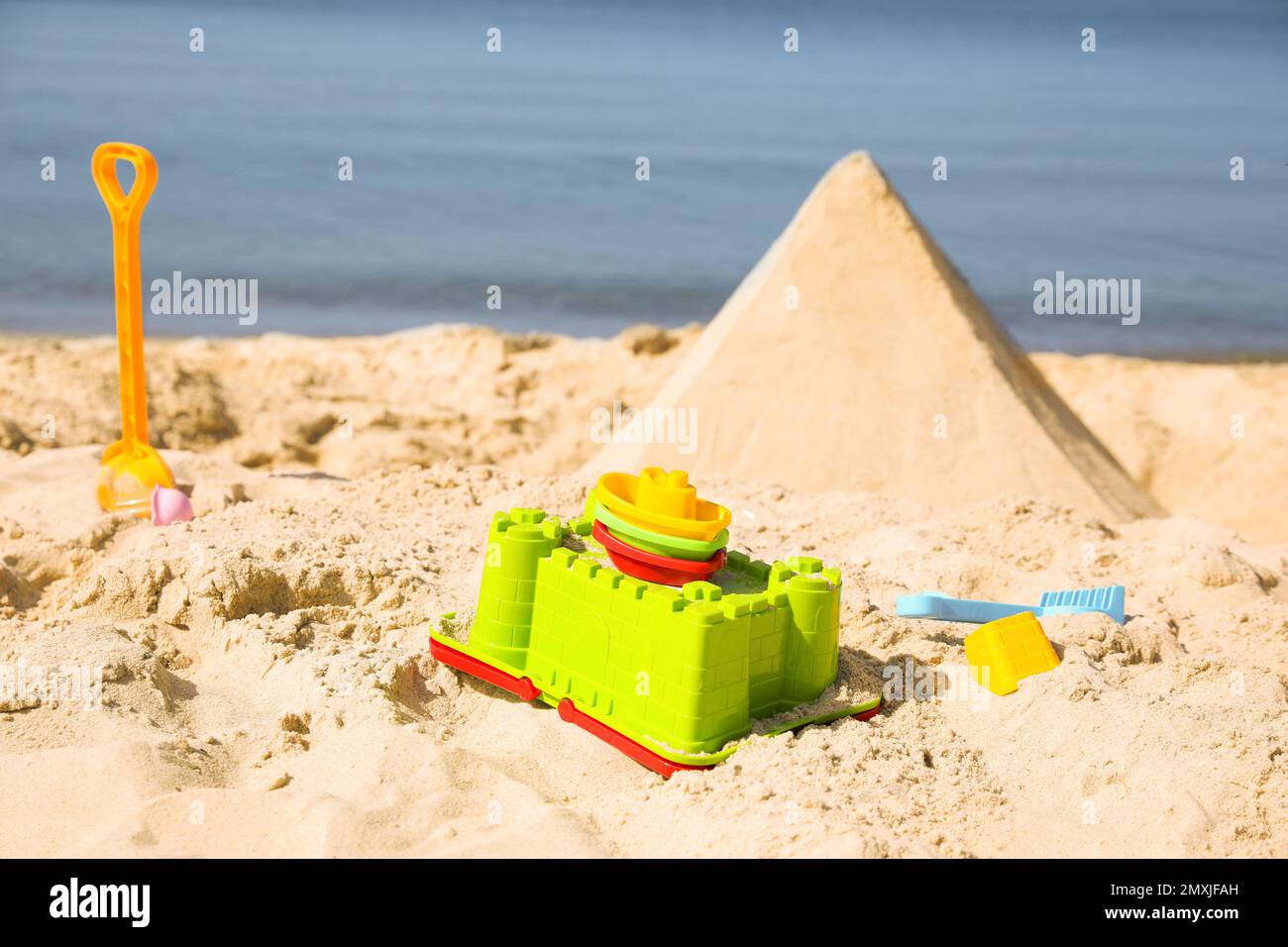 Different child plastic toys on sandy beach Stock Photo - Alamy
