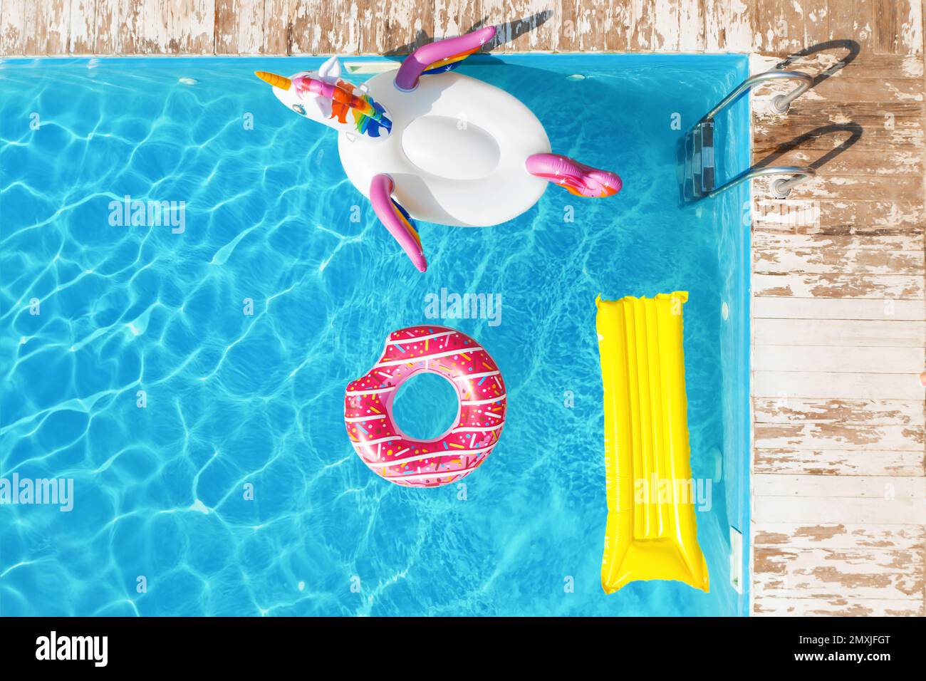 Swimming pool with inflatable rings and mattress, top view Stock Photo ...