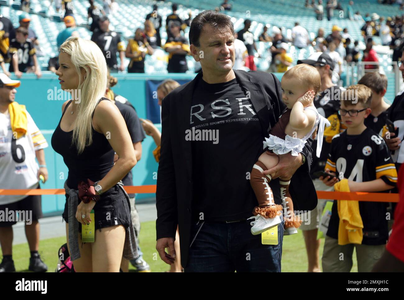 Sports agent Drew Rosenhaus holds his daughter Elle as he stands with his wife Lisa Thomson ...