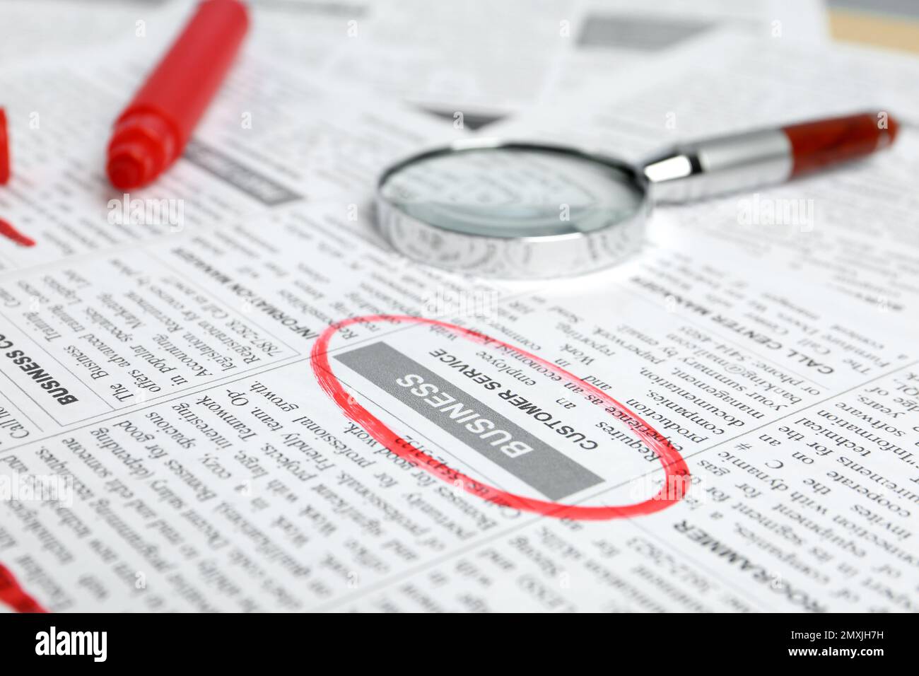Newspaper with marked advertisement and magnifying glass. Search ...