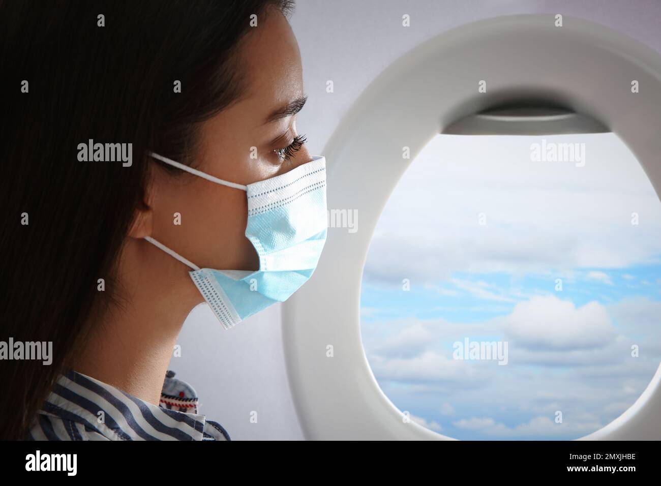 Traveling by airplane during coronavirus pandemic. Woman with face mask ...
