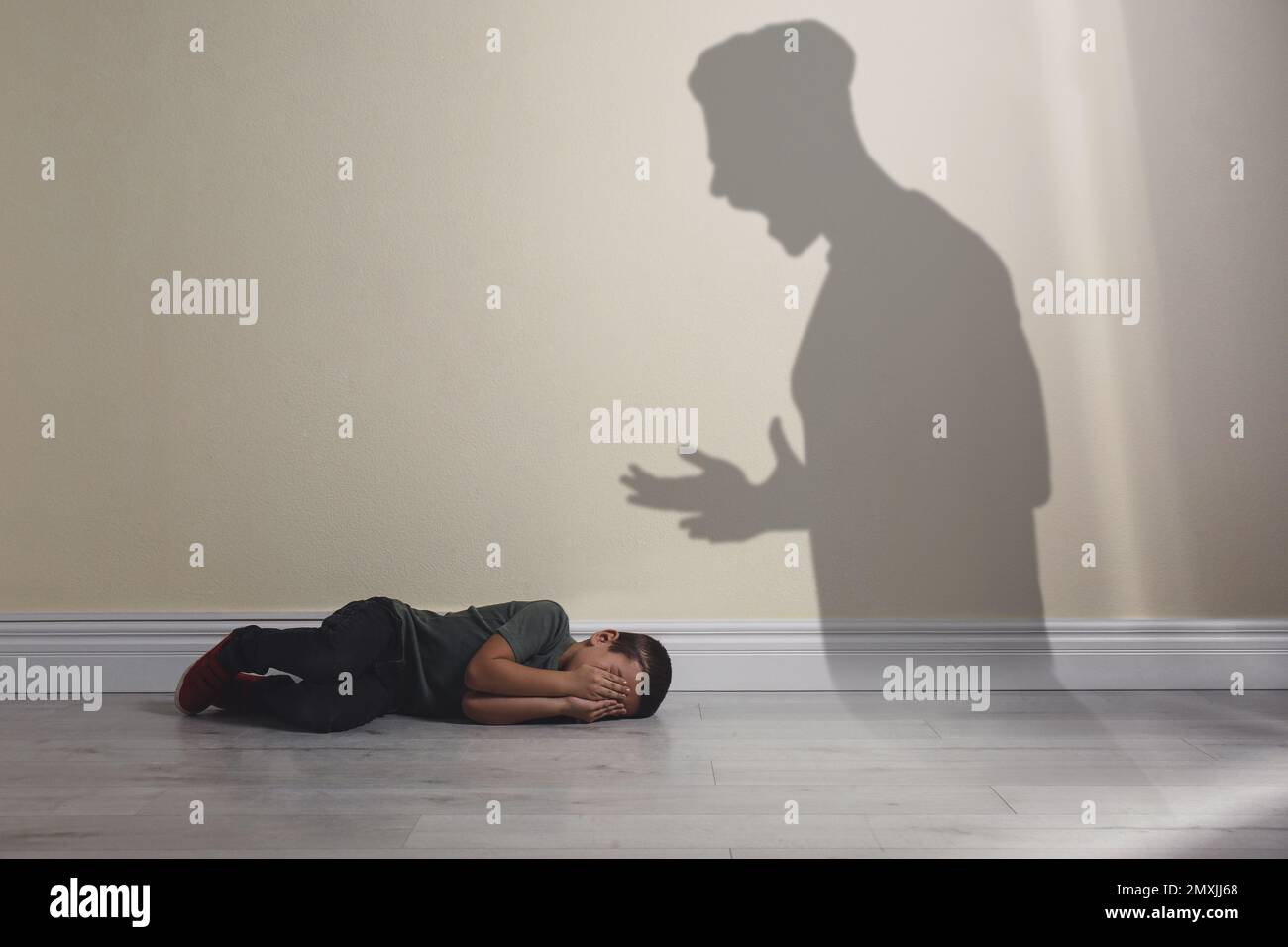 Child abuse. Father yelling at his son. Shadow of man on wall Stock ...