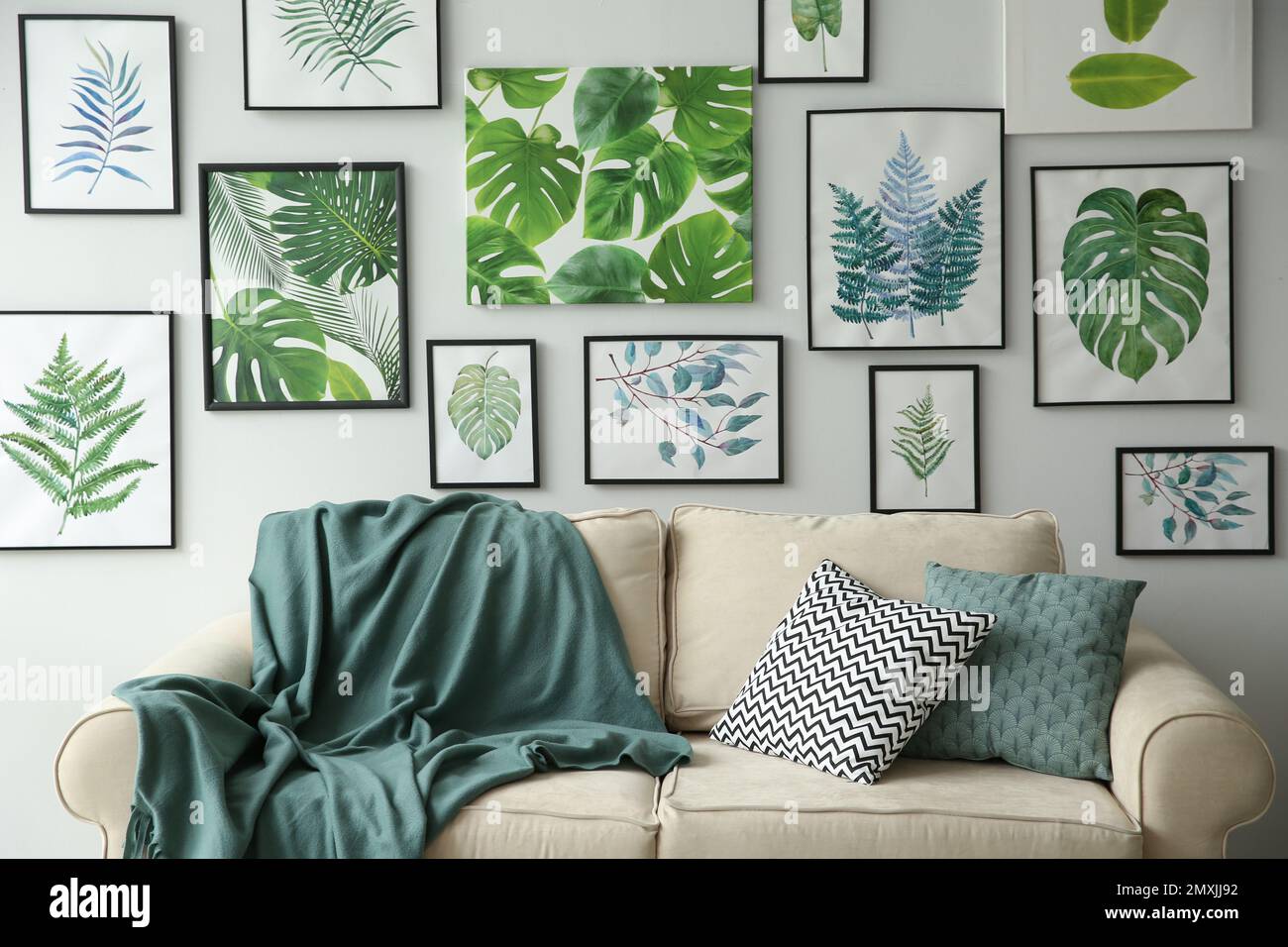 Beautiful artworks and comfortable couch in stylish room. Interior ...