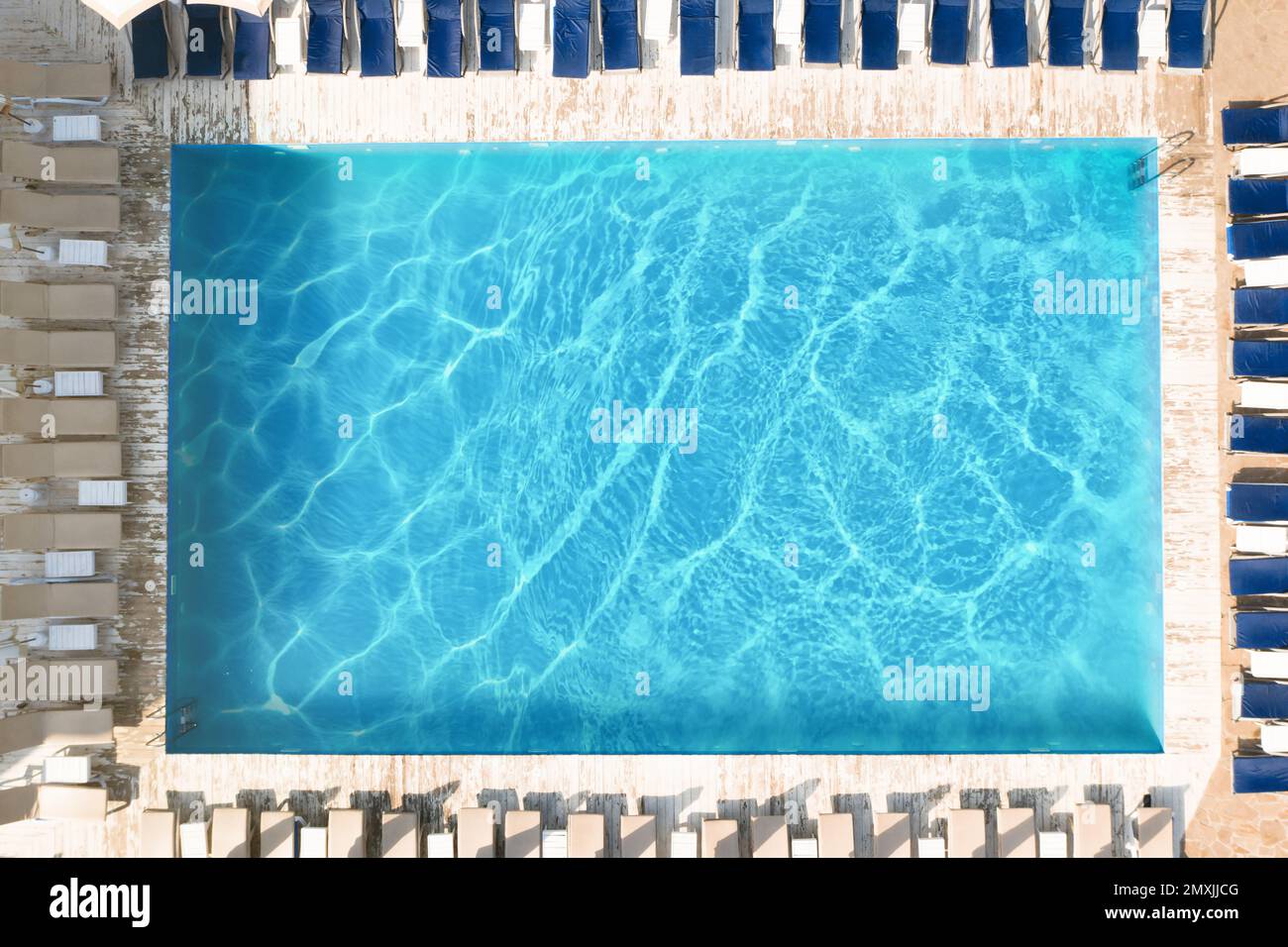 Sun lounge chairs near swimming pool, top view Stock Photo - Alamy