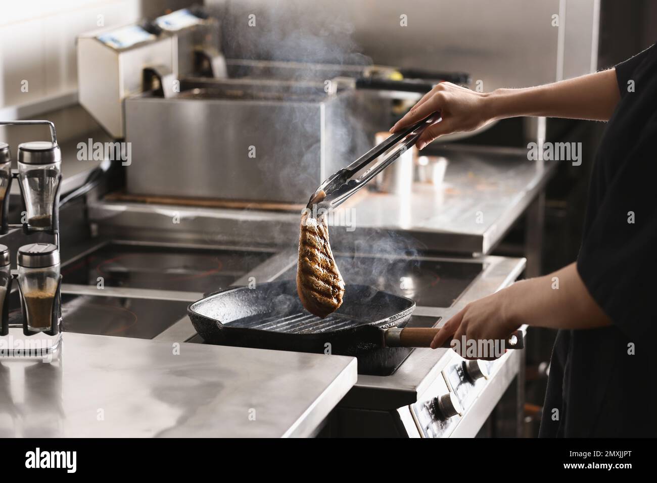 Young woman cooking frying chicken hi-res stock photography and images ...