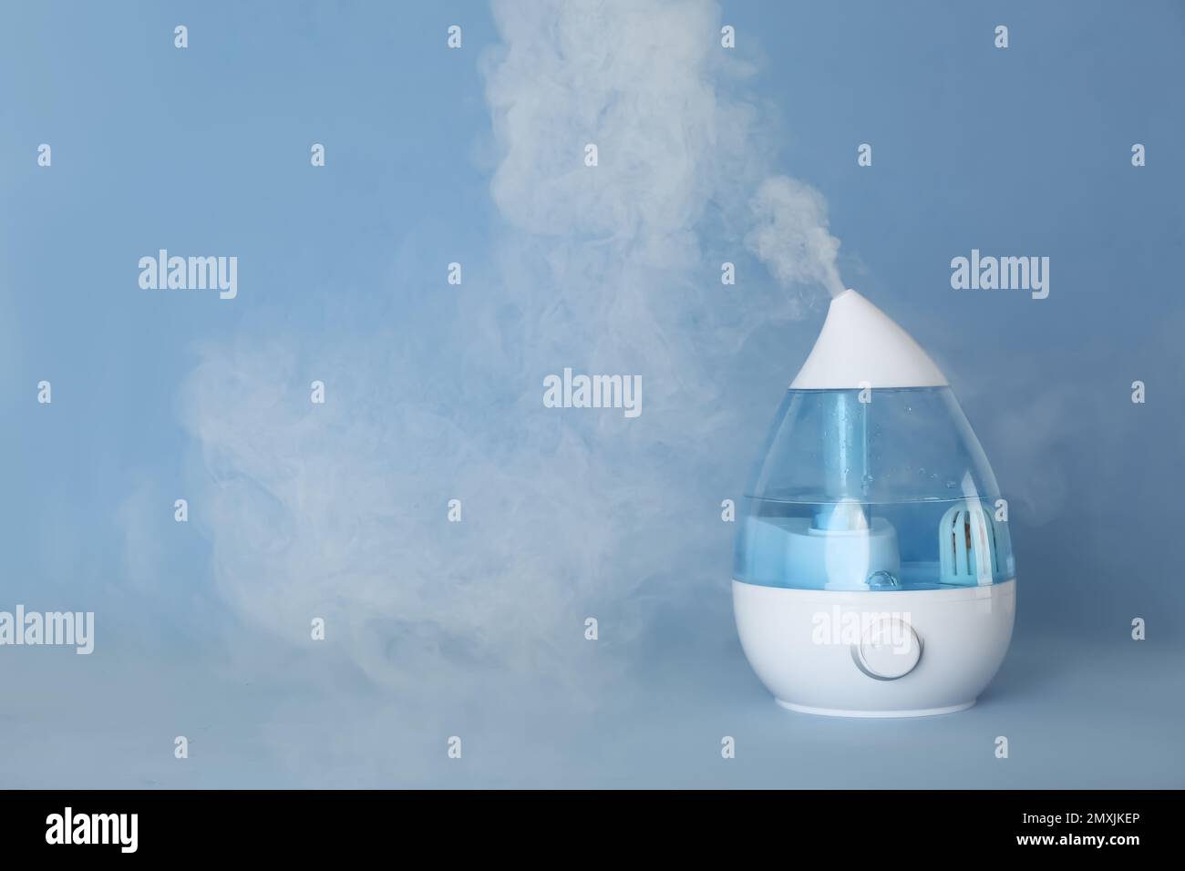 Modern air humidifier on light blue background. Space for text Stock ...