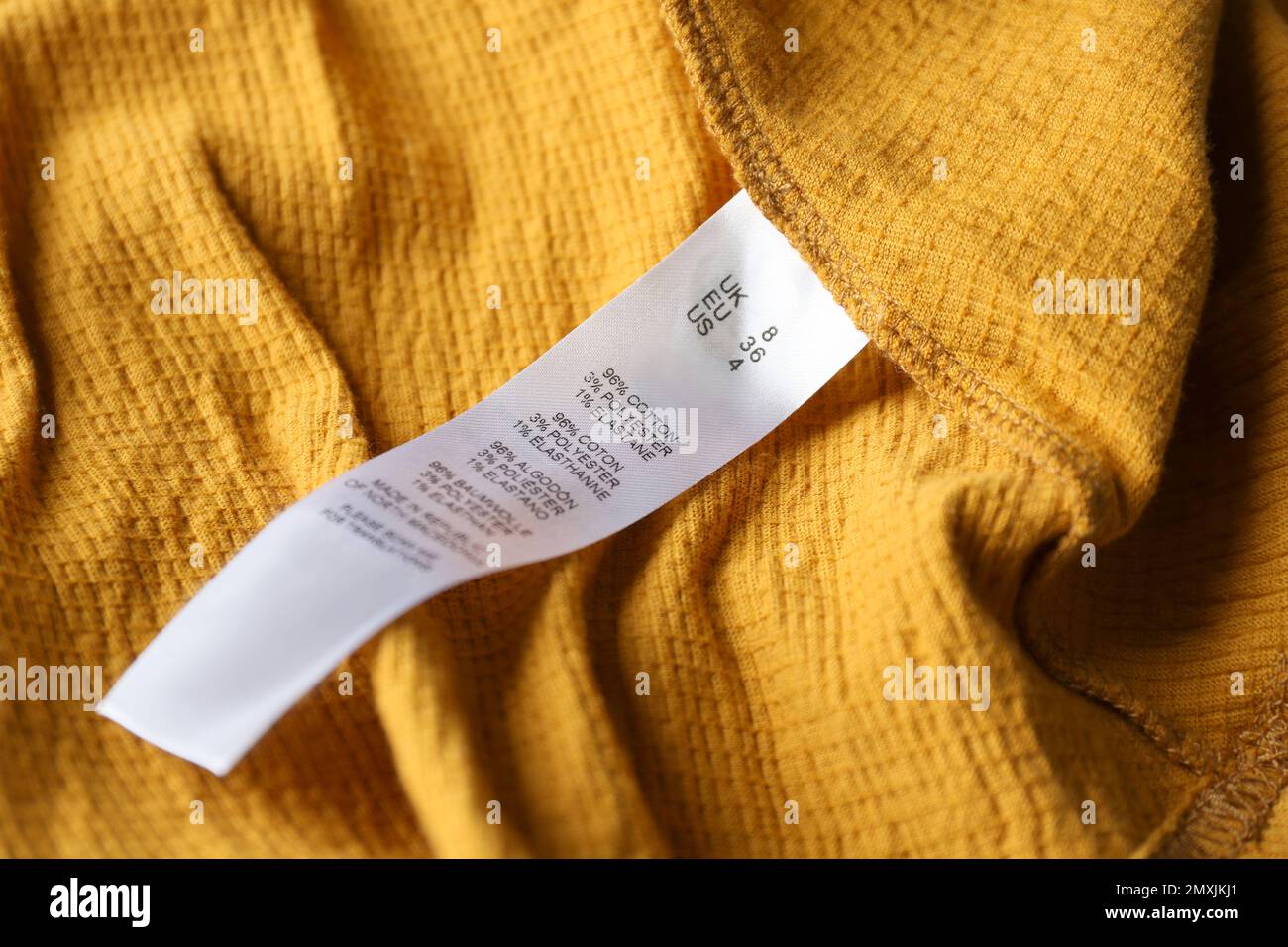 Clothing label with size and content information on yellow garment ...