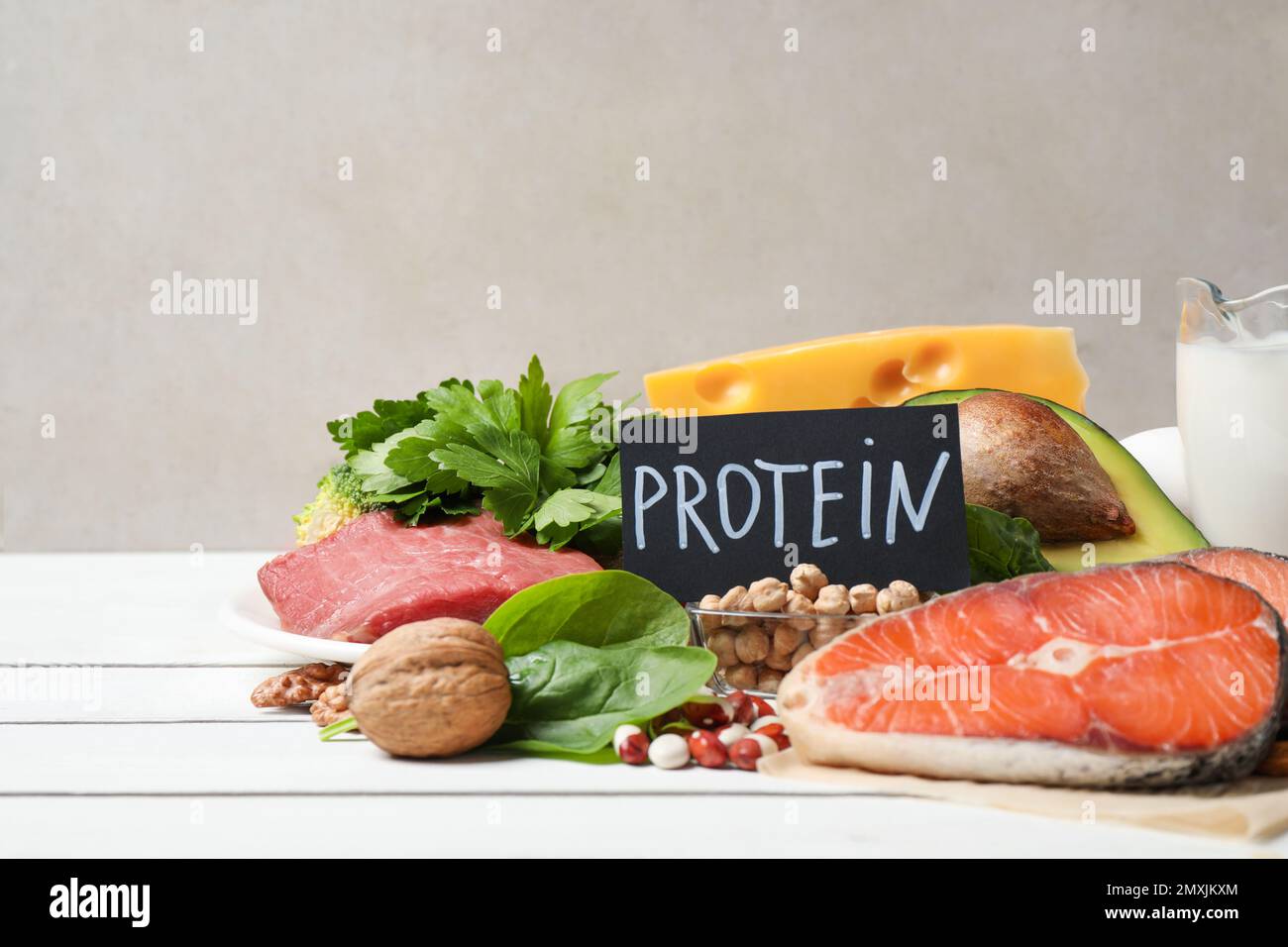 Card with word PROTEIN and different products on white wooden table ...