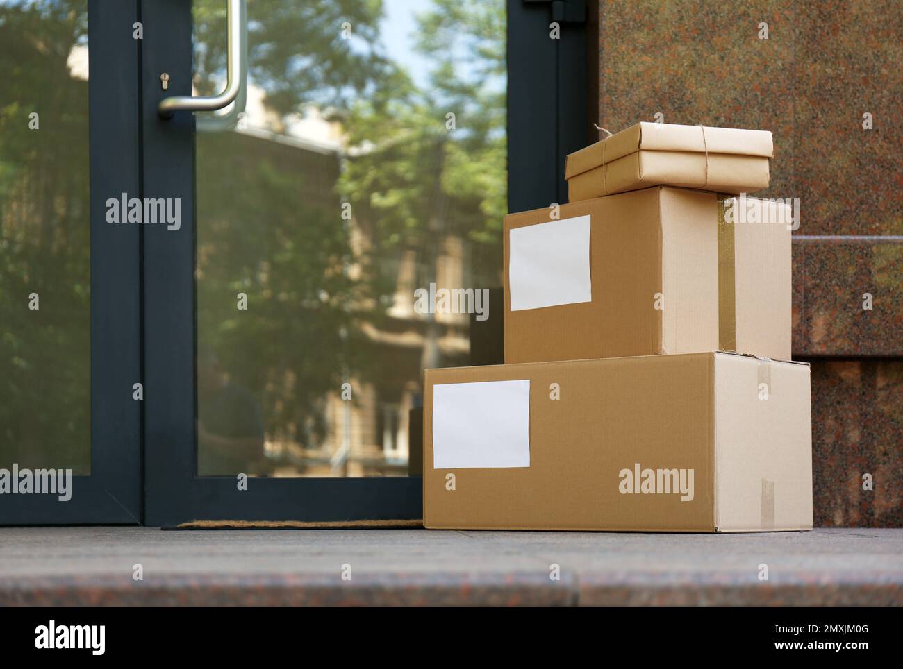 Delivered parcels on porch near front door Stock Photo - Alamy