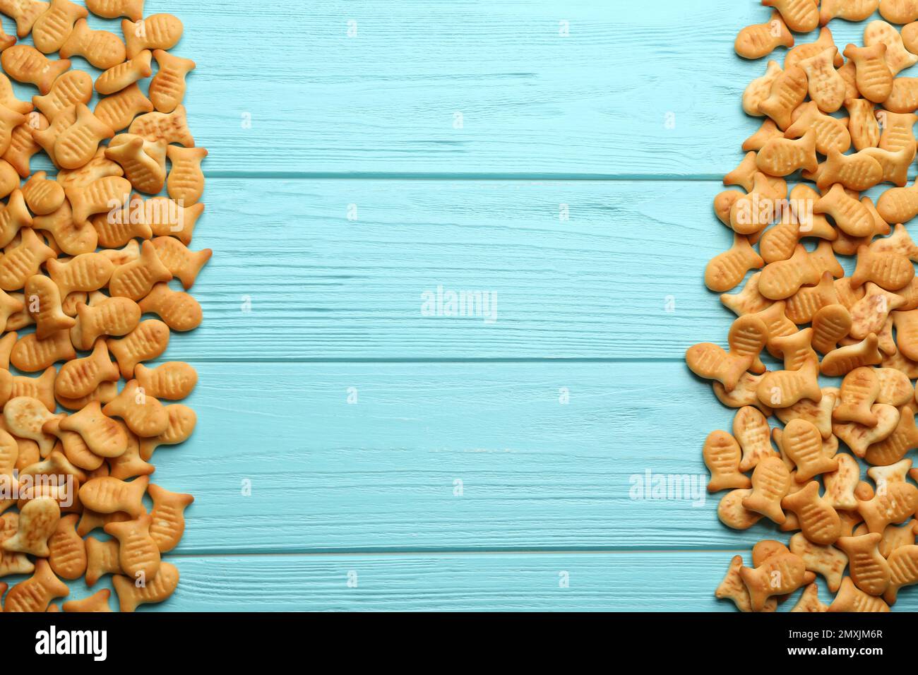 Delicious fish shaped crackers on light blue wooden table, flat lay ...