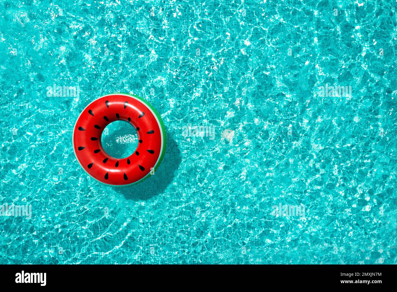 Inflatable ring floating in swimming pool, top view with space for text ...