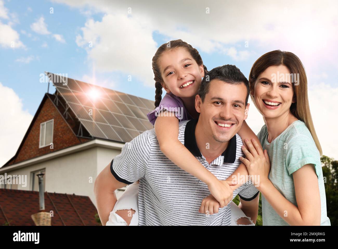 Happy family near their house with solar panels. Alternative energy ...