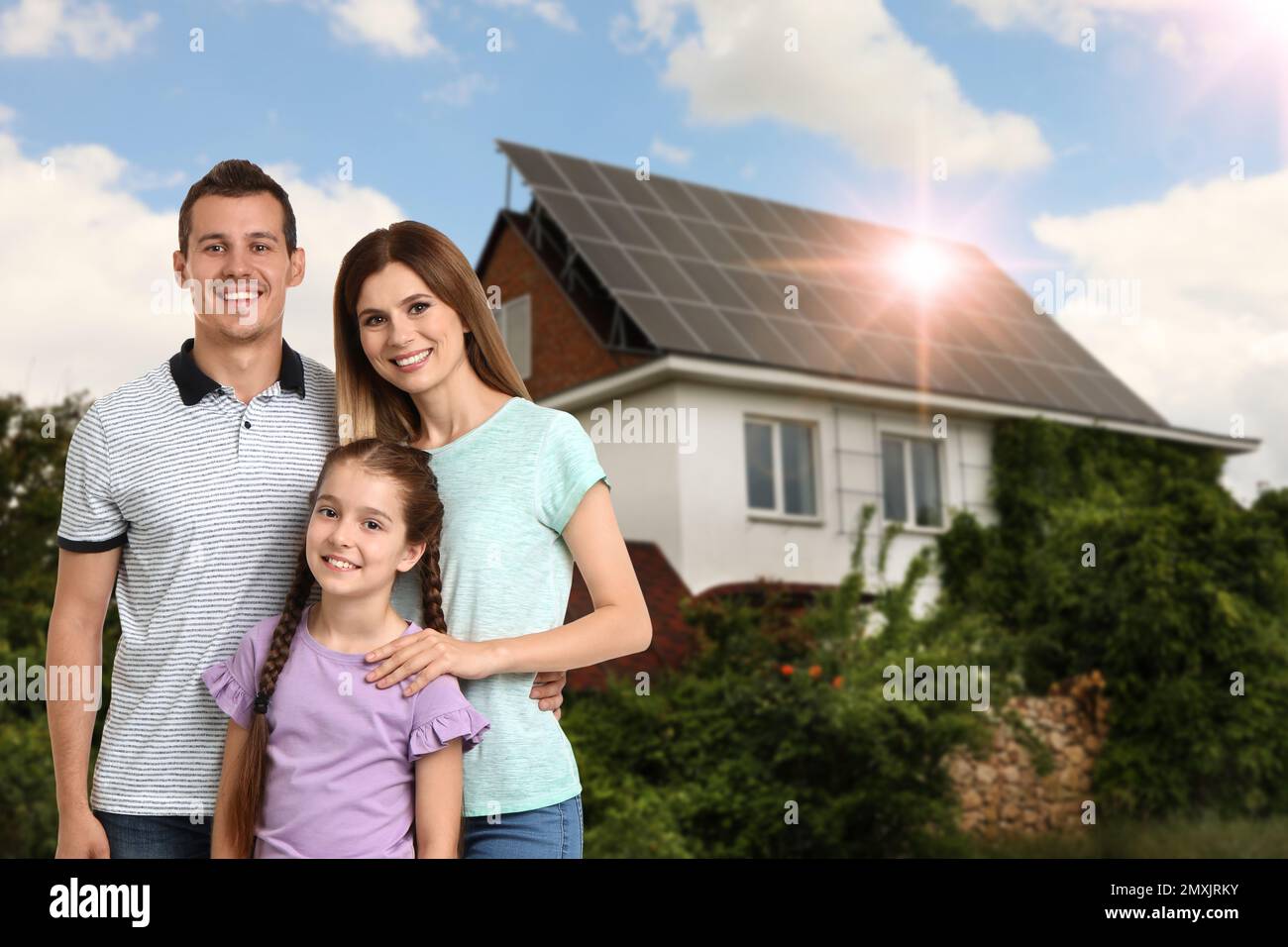 Happy family near their house with solar panels. Alternative energy ...
