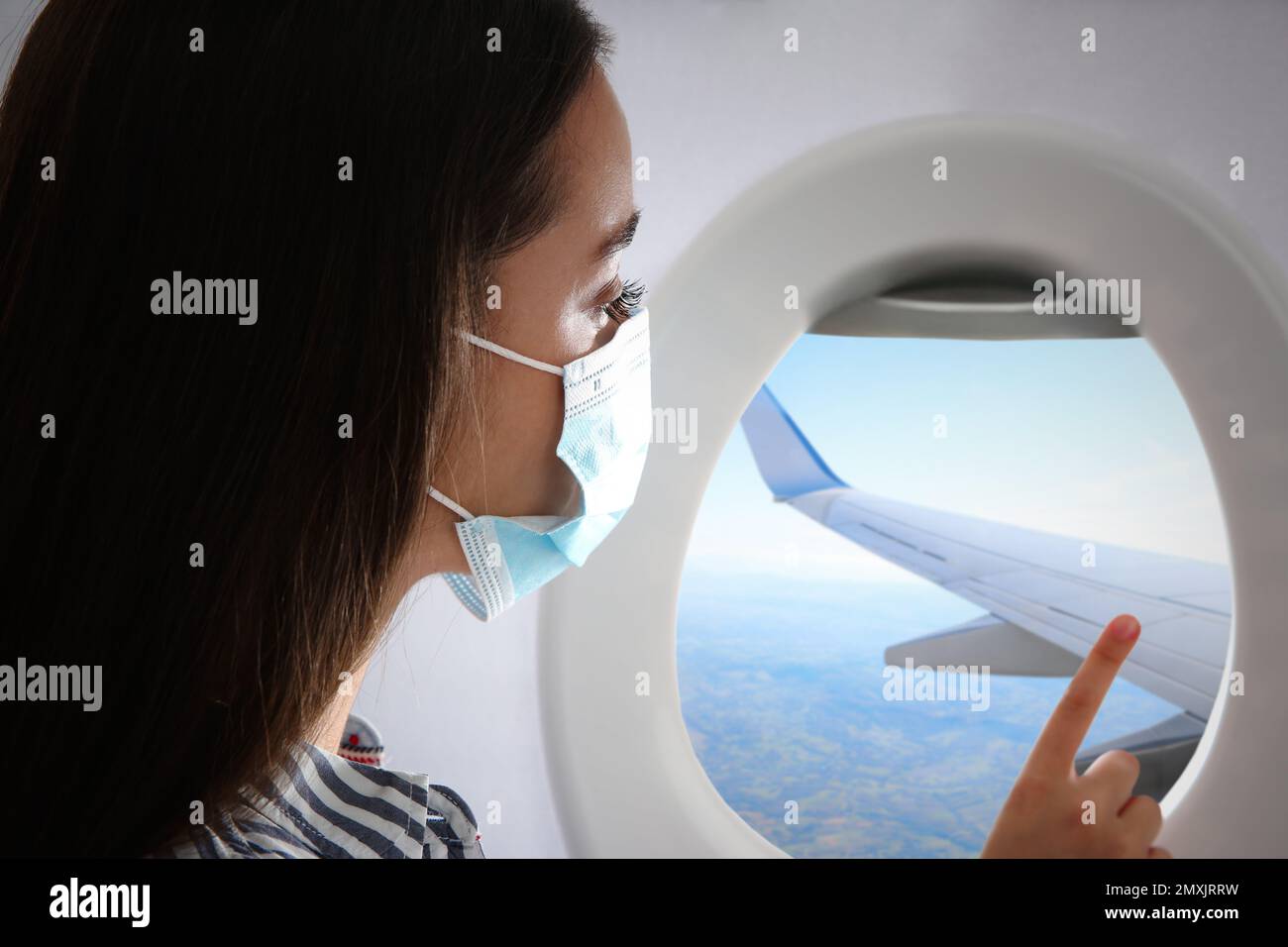 Traveling by airplane during coronavirus pandemic. Woman with face mask ...