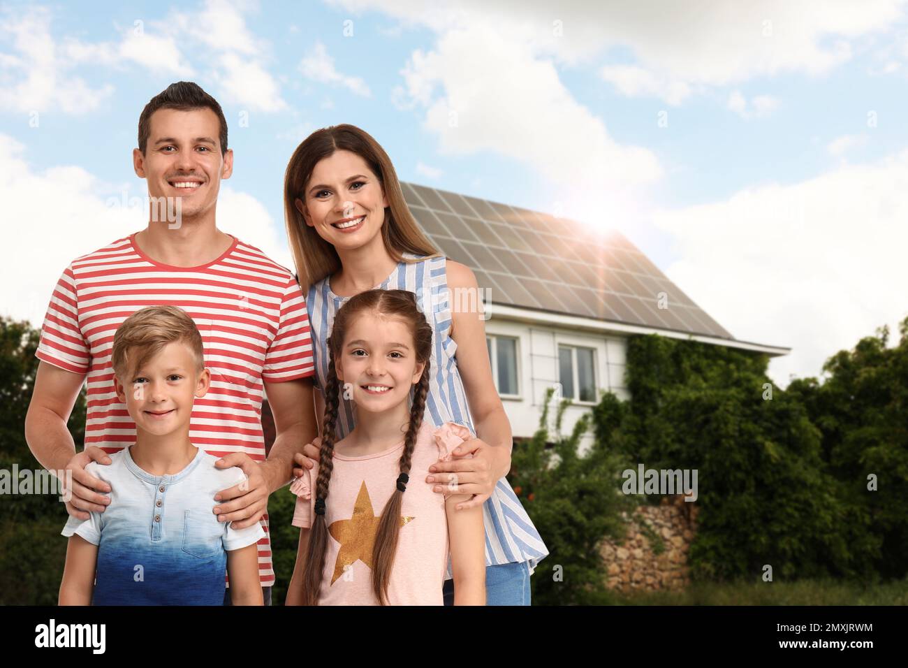 Happy family near their house with solar panels. Alternative energy ...