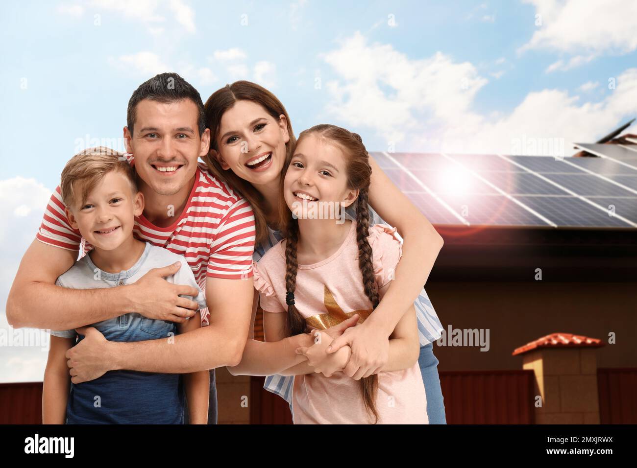 Happy family near their house with solar panels. Alternative energy ...