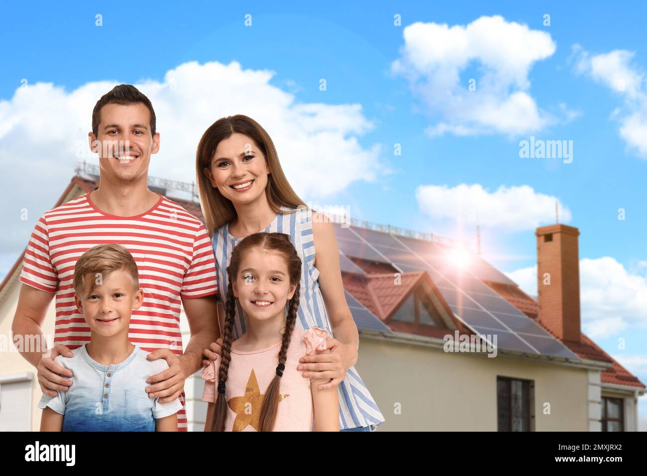 Happy family near their house with solar panels. Alternative energy ...