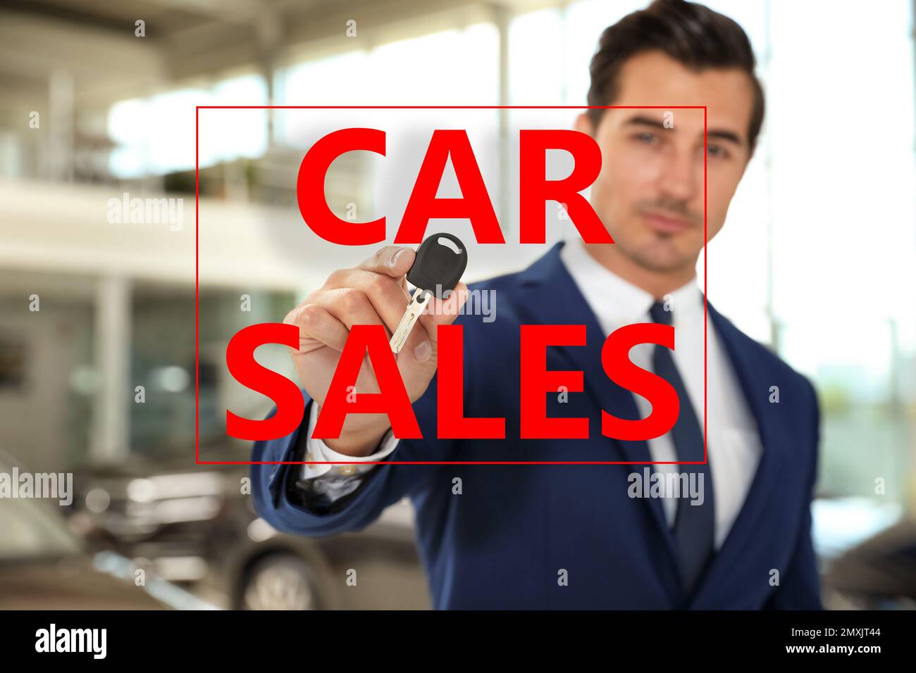 Salesman with key in car dealership, focus on hand Stock Photo - Alamy