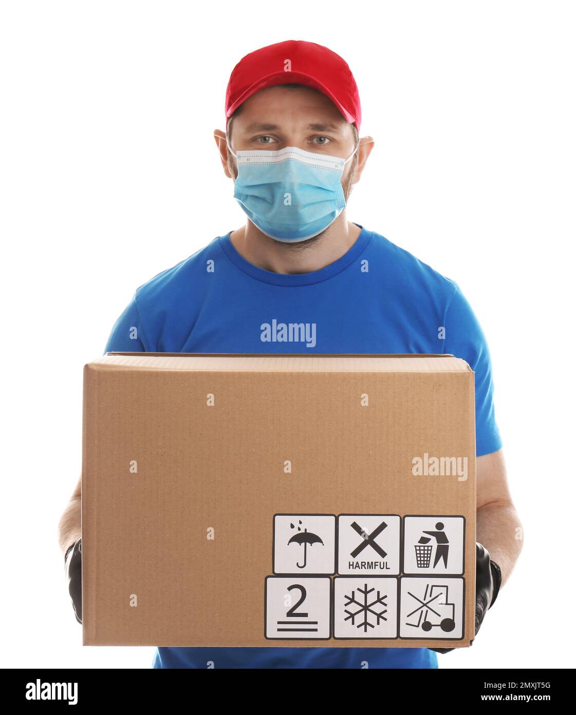 Courier in mask holding cardboard box with different packaging symbols ...