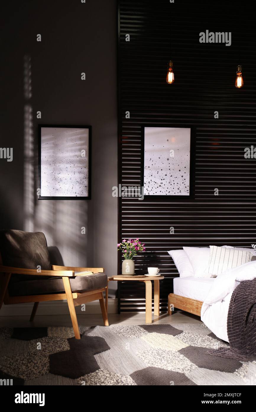 Comfortable bedroom with armchair and pictures on wall. Interior design ...