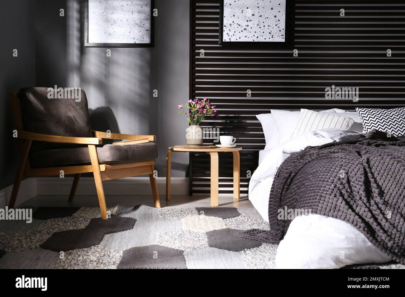 Comfortable bedroom with armchair and pictures on wall. Interior design ...