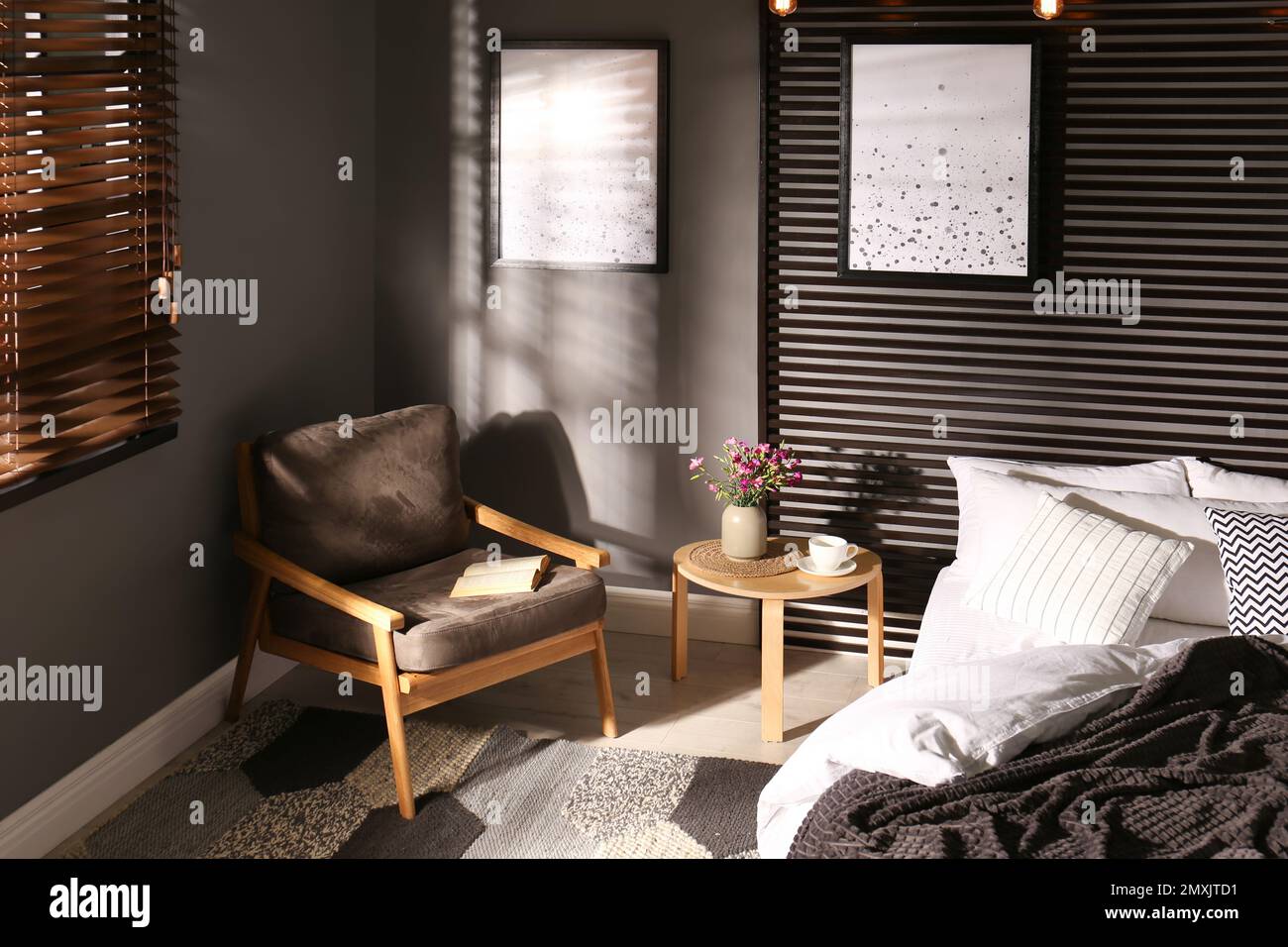 Comfortable bedroom with armchair and pictures on wall. Interior design ...