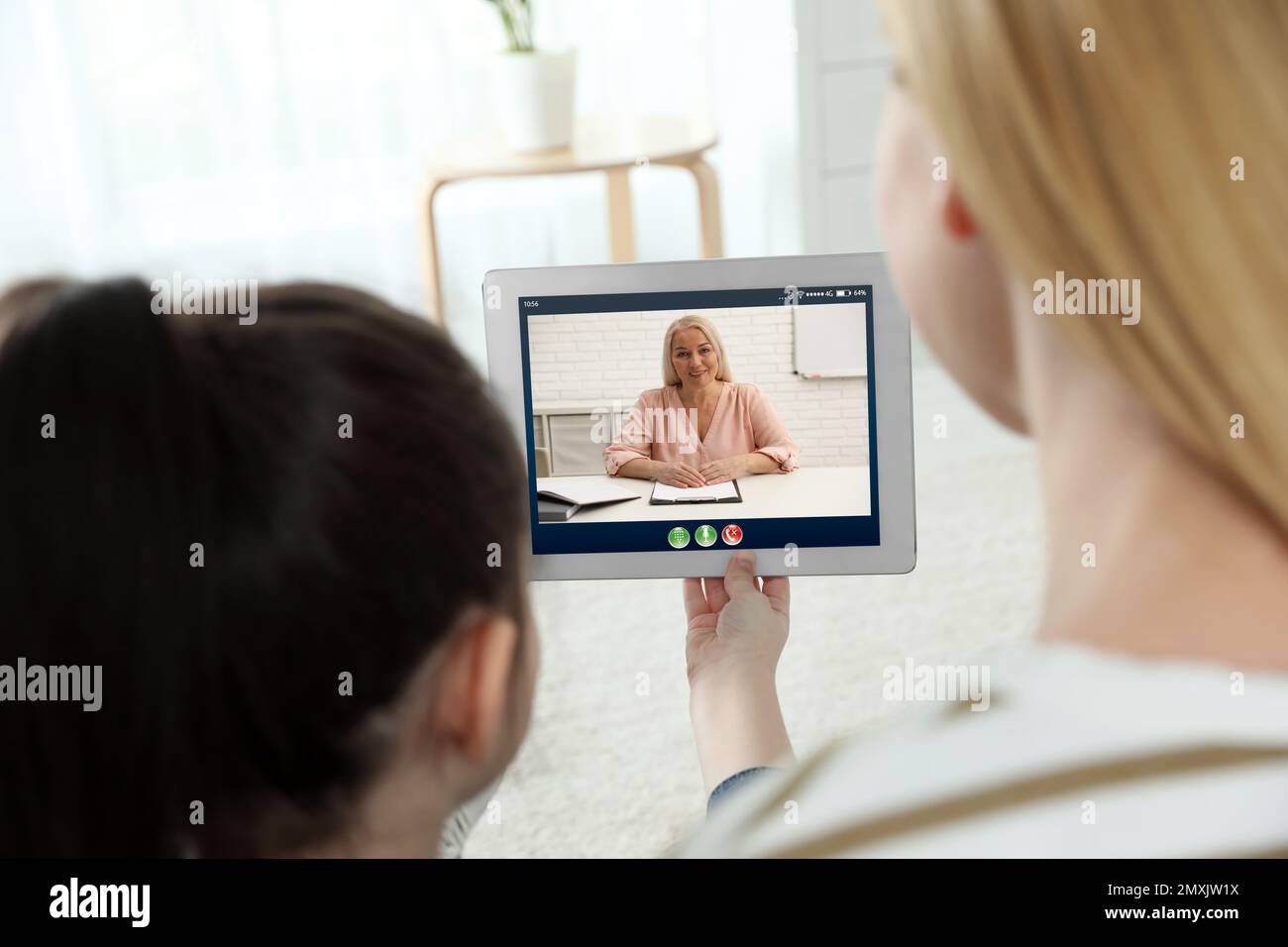 Distance learning, studying at home. Girl with her mother watching online school lesson during ...
