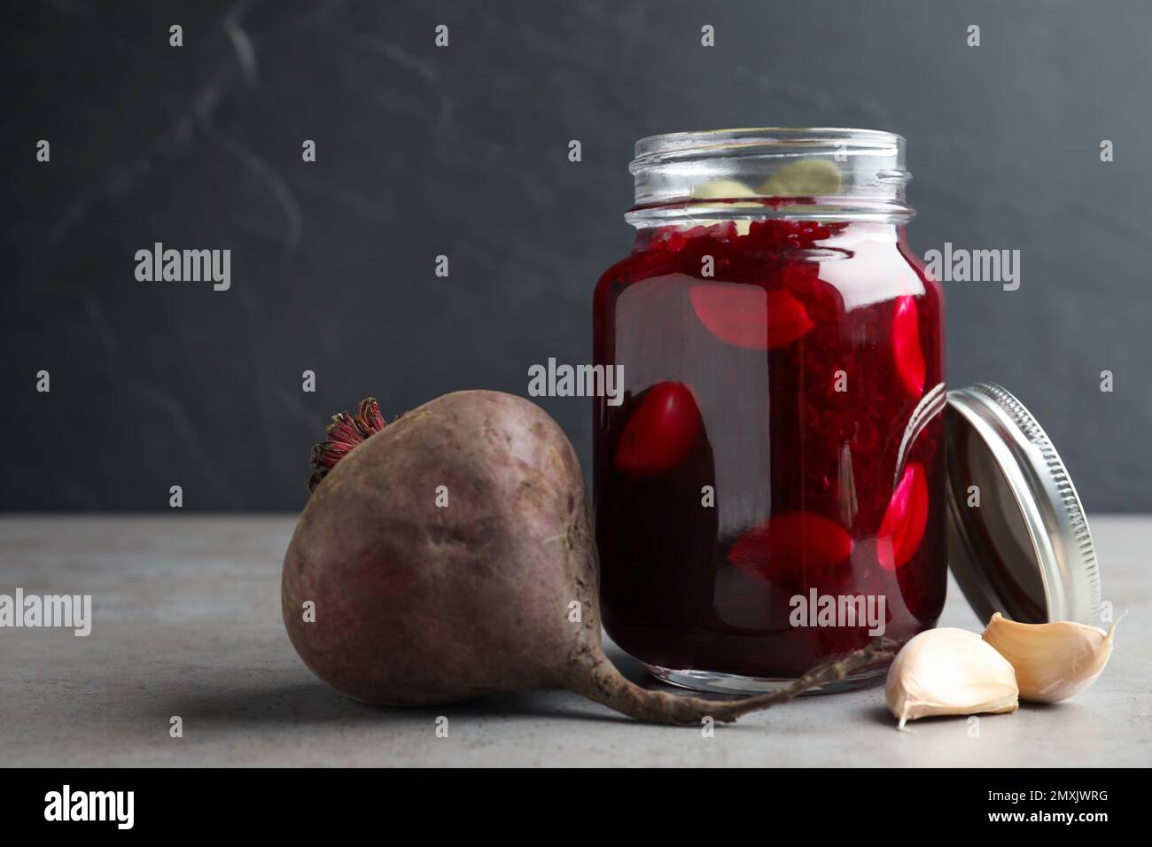 Pickled beets in glass jar on light table against dark background Stock ...