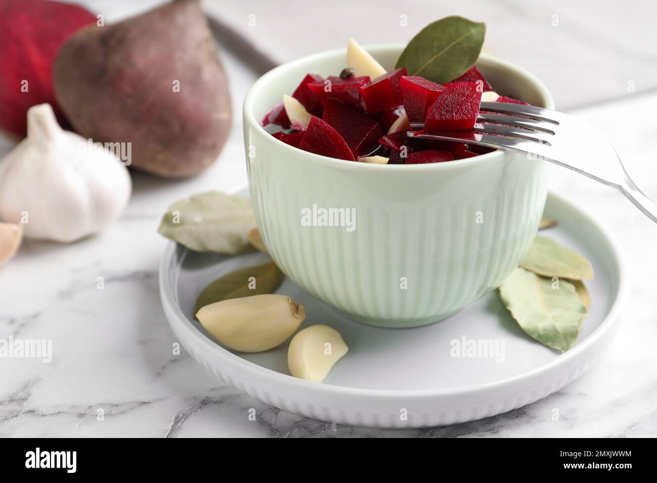 Pickled beets with garlic in bowl on white marble table Stock Photo - Alamy