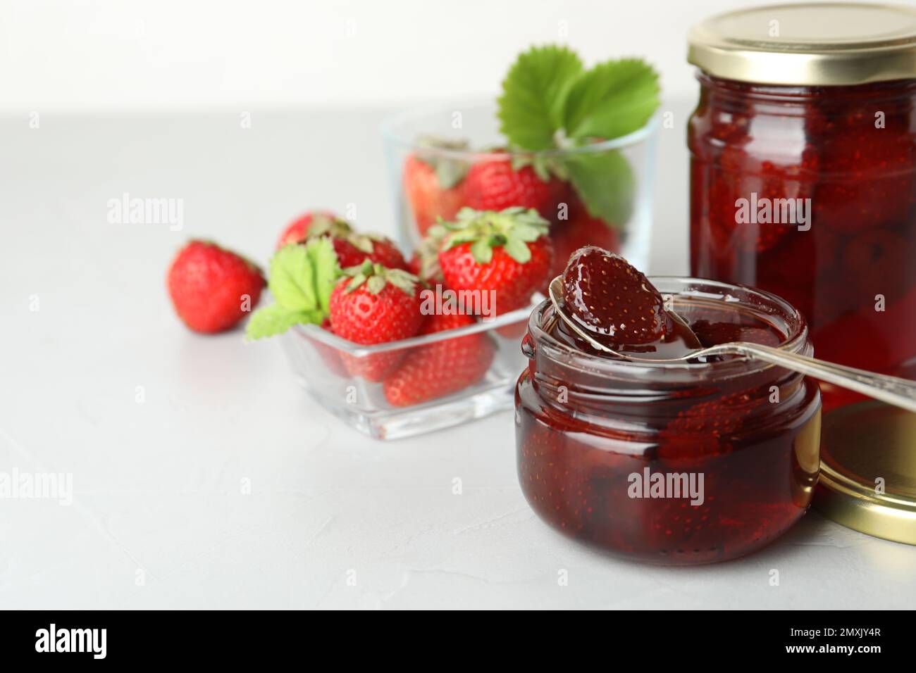 Delicious pickled strawberry jam and fresh berries on light table ...