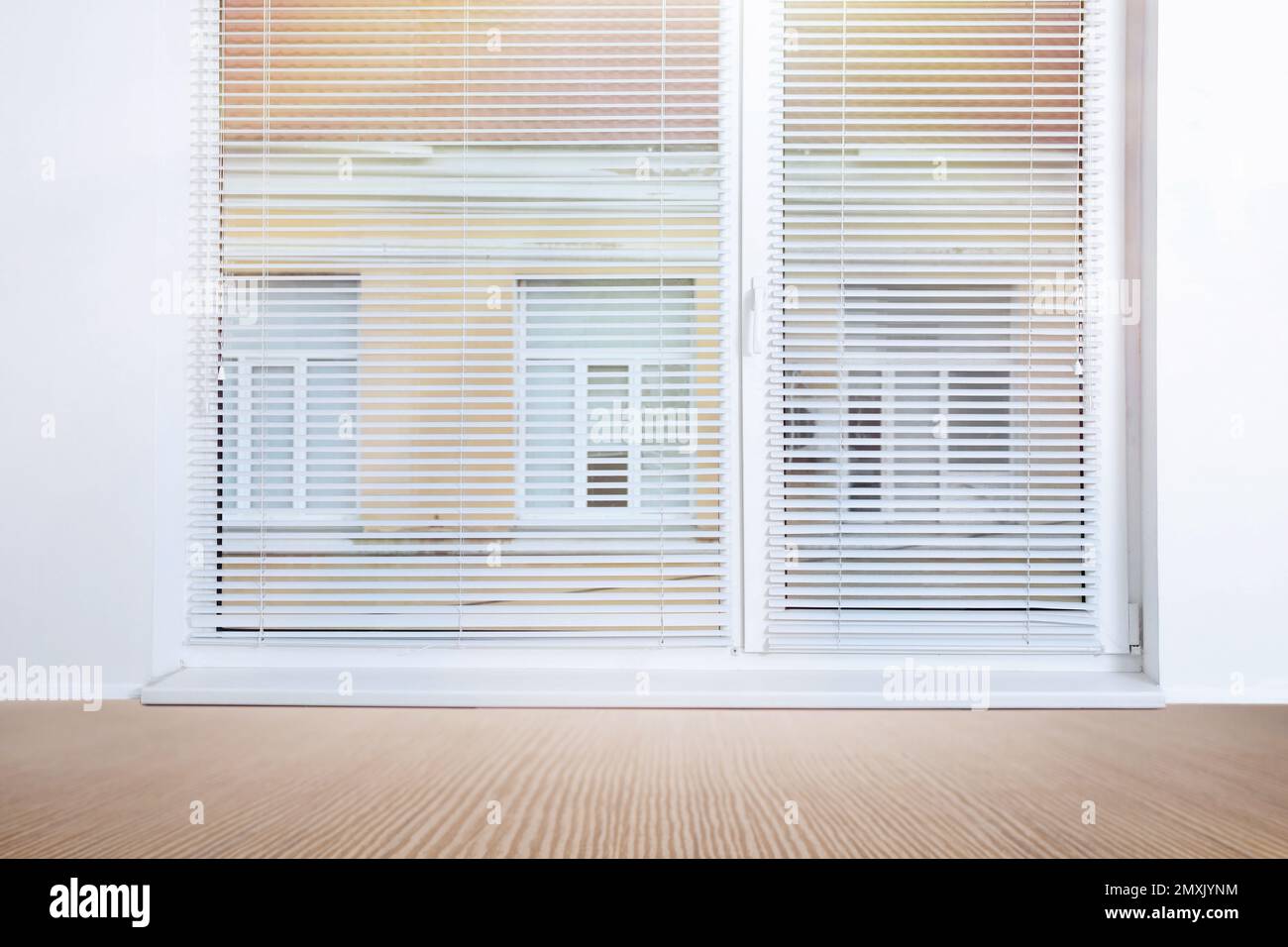 Wooden table and window with blinds on background Stock Photo - Alamy