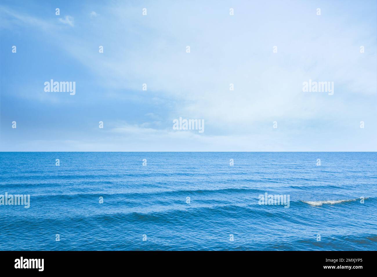 Beautiful wavy sea under blue sky with clouds Stock Photo - Alamy