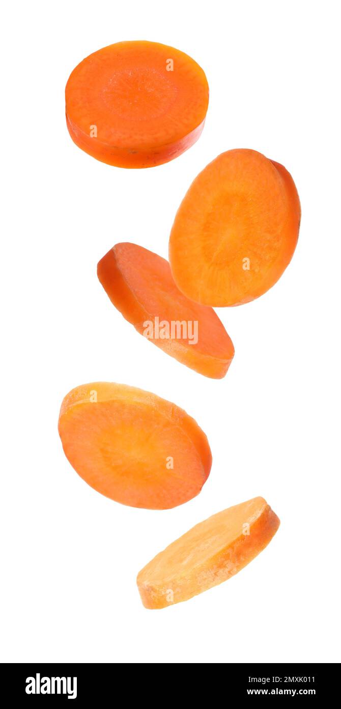 Fresh carrot slices falling on white background Stock Photo - Alamy