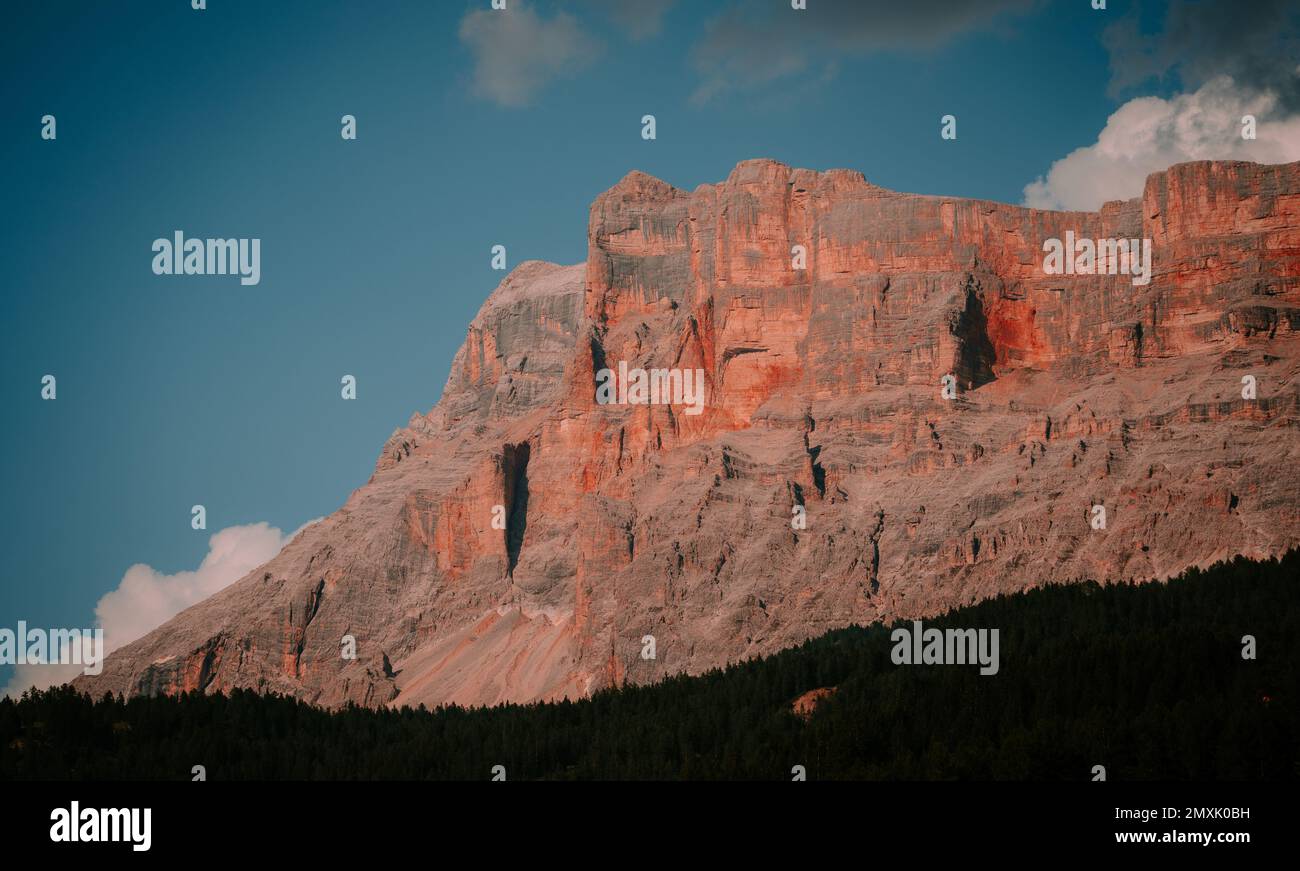 A low-angle of sunlit Dolomites mountain view at sunset, clear sky ...