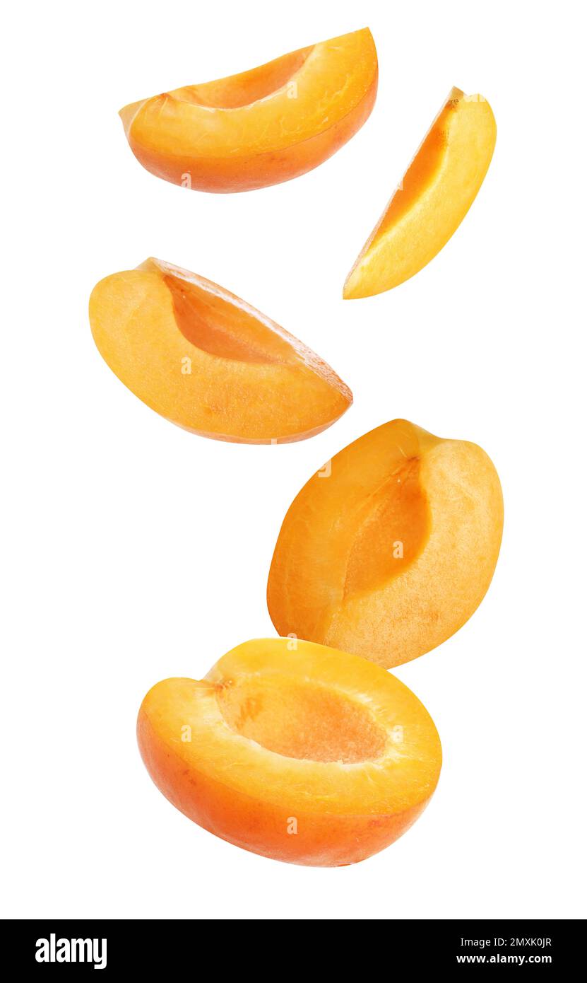 Cut ripe apricots falling on white background Stock Photo - Alamy