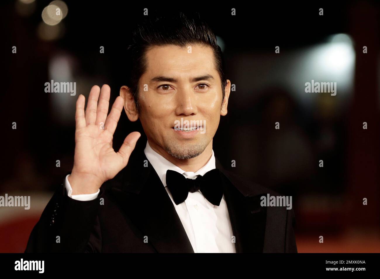 Actor Masahiro Motoki poses for photographers as he arrives on the red ...