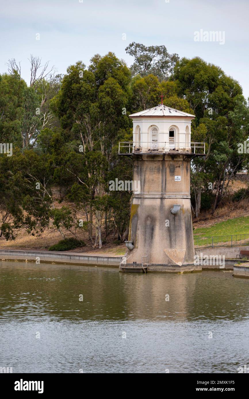 The vertical view of an aged watchtower and trees by the water Stock ...