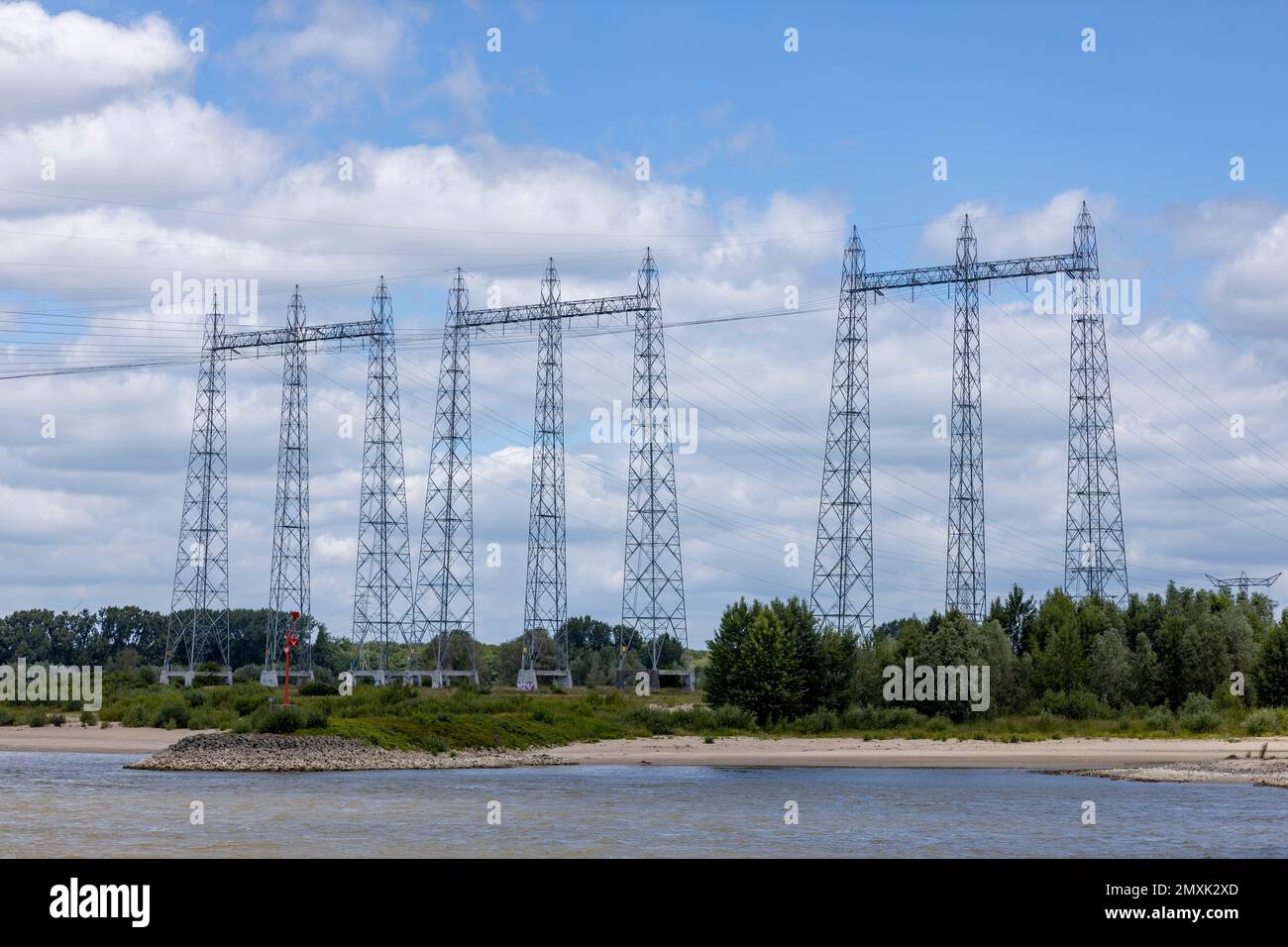 High voltage electricity towers energy industry at the shore of river ...