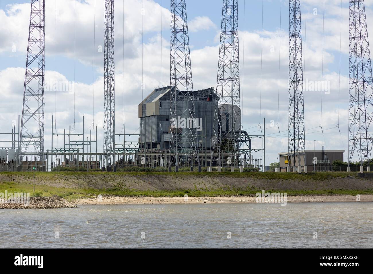 Industrial building behind high voltage electricity towers energy ...