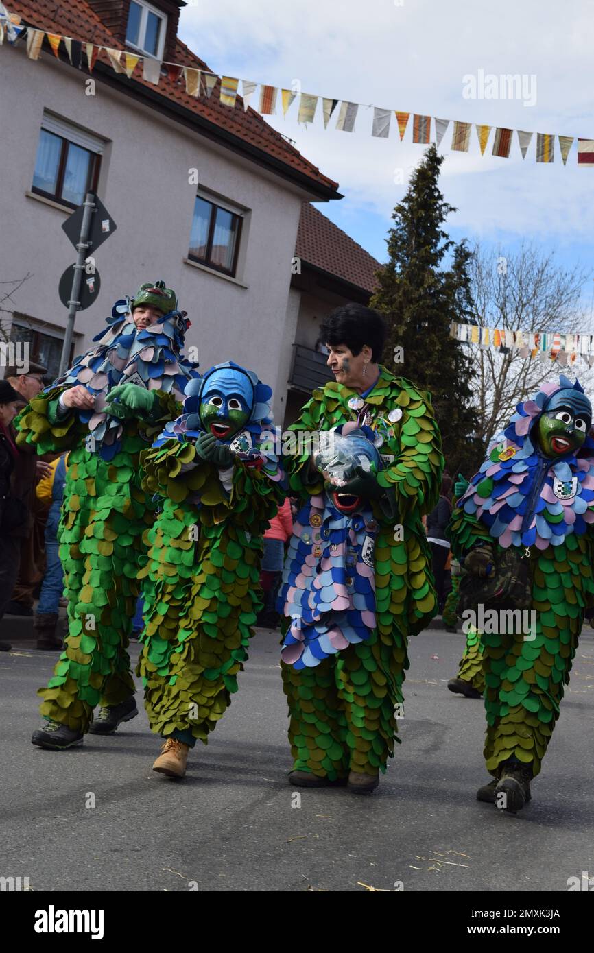 A vertical shot of people dressed in festive costumes celebrating the ...